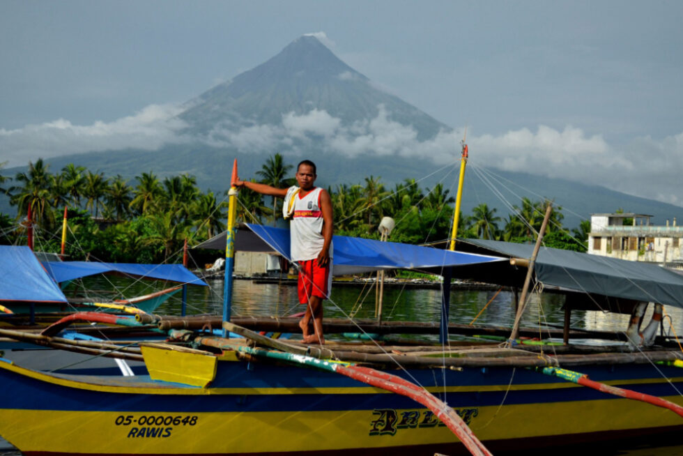 a-fisherman-under-the-shadow-of-mayon-volcano-in-malbay-province-luzon ...